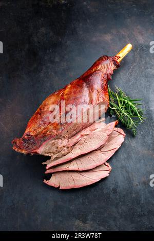 Traditional barbecue leg of venison sliced and served as top view on ...
