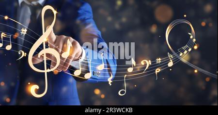 Musician pointing at staff with music notes and symbols on color ...