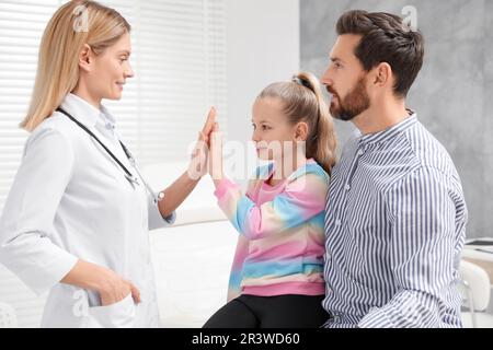 Happy father and daughter having appointment with doctor. Pediatrician ...