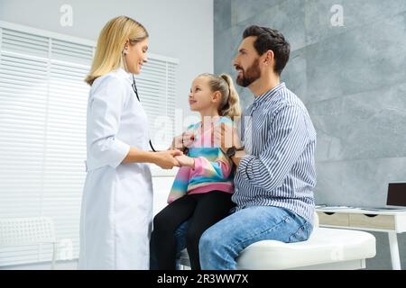 Father and daughter having appointment with doctor. Pediatrician ...