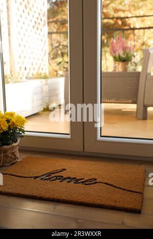 Doormat with word Home on parquet floor indoors Stock Photo - Alamy
