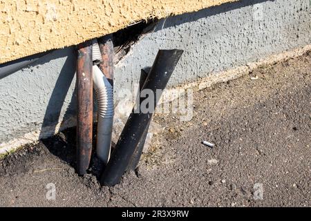 Electrical wires stick out of the ground near the house Stock Photo - Alamy