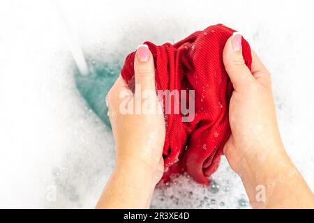 Female hands washing bright red shirt Stock Photo - Alamy