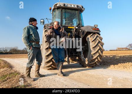 Farmers' retirement pension: two farmers talking near a tractor, one ...