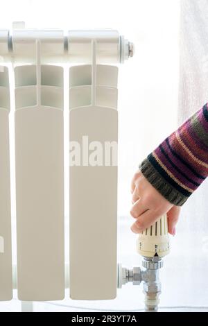 Radiator adjustment closeup. Female hand adjusting radiator temperature ...