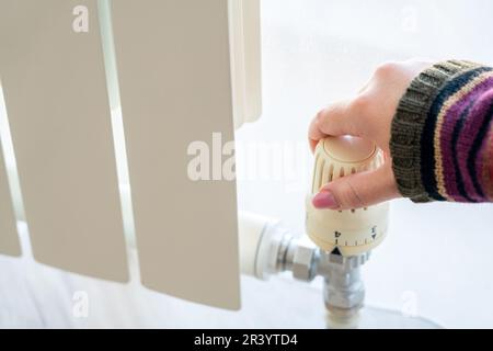 Radiator adjustment closeup. Female hand adjusting radiator temperature ...