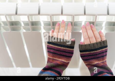 Girl warms up the frozen hands above hot radiator, close up view Stock ...
