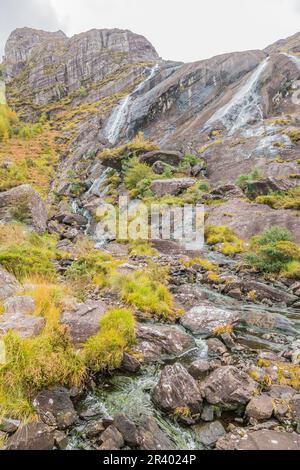 Typical Irish landscape with green meadows and rough mountains during ...