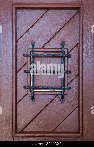 Locked wooden door with a barred window, attached to a traditional ...