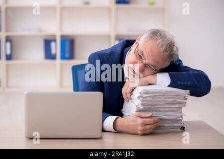 Old employee unhappy with excessive work in the office Stock Photo - Alamy