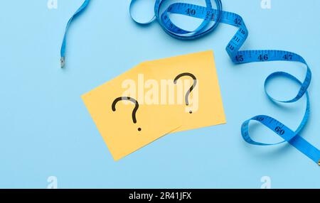 Measuring tape and stickers with question marks, weight loss concept ...