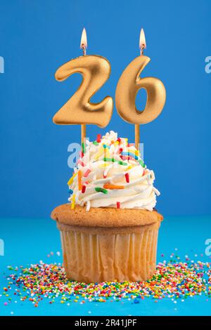 Number 26 blue celebration candle and gold confetti on dark wooden ...