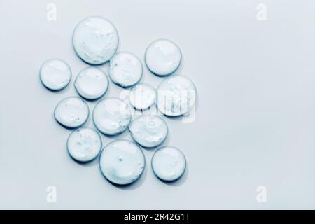 Liquid gel abstract cosmetic swatch drops on blue background. Smear of ...