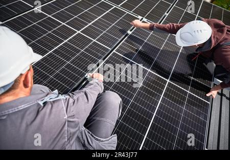 Engineers together installing solar panels on roof Stock Photo - Alamy