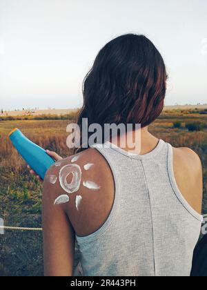Old woman with sun cream on the sandy beach Stock Photo - Alamy