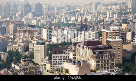 An aerial cityscape view of Tehran with multiple power lines ...