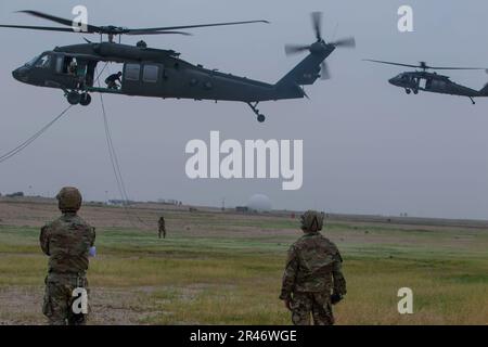 Soldiers look on as the rappel master instructors prepare to ...