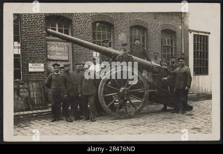 Unidentified German soldiers in uniform with gas masks loading cannon ...
