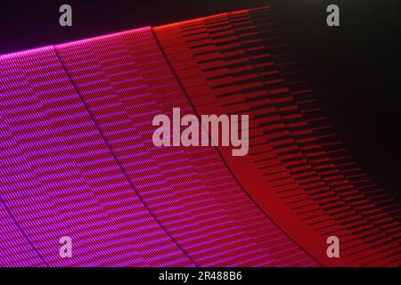 A large display featuring a pattern of purple and red lights radiating ...