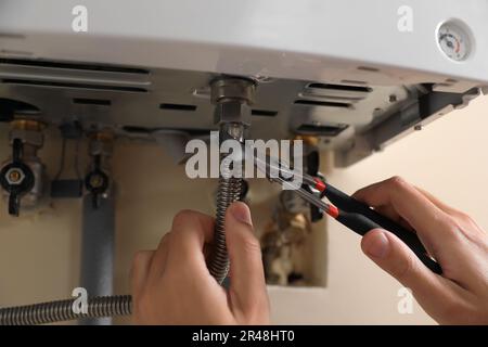 Man repairing gas boiler with waterpump plier, closeup Stock Photo - Alamy