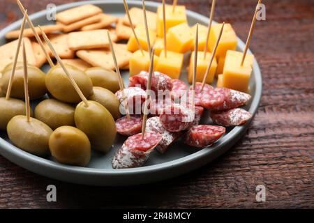 Toothpick appetizers. Pieces of cheese, sausage and olives on light ...