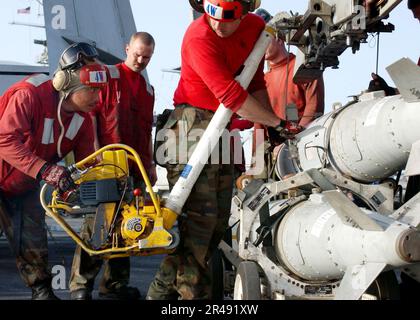US Navy Aviation Ordnancemen load a 500lb. Mk-82 general purpose bomb on an F-A-18E Super Hornet ...