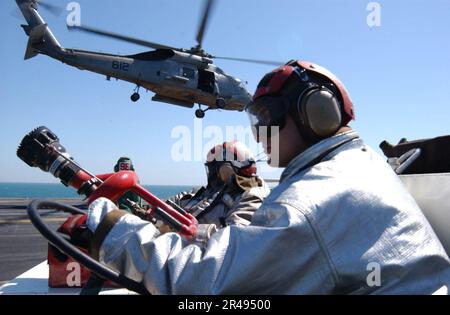 US Navy Crash and Salvage crewmembers spray-down the flight deck during ...
