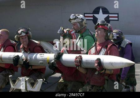 US Navy Aviation Ordnanceman lift an AIM-120 Advanced Medium-Range Air ...