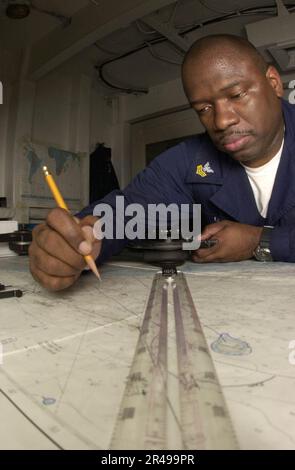 US Navy Quartermaster 1st Class talks on a hand held radio while ...