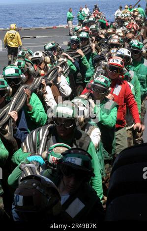 Flight deck personnel re-stow fixed-wing aircraft arrested landing ...