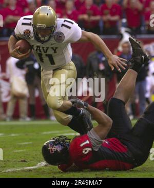 US Navy Texas Tech quarterback passes the ball as Navy linebacker leaps ...