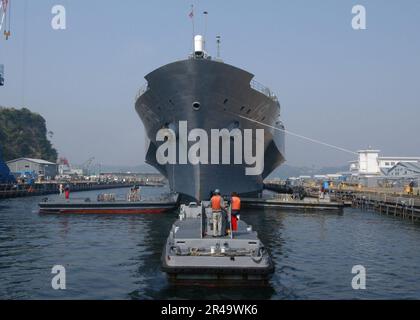 US Navy Small barges maneuver the 7th Fleet command and control ship ...