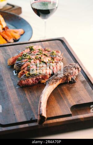 Slices of Medium Rare Bone-in Prime Rib with Au Jus: Carved standing ...