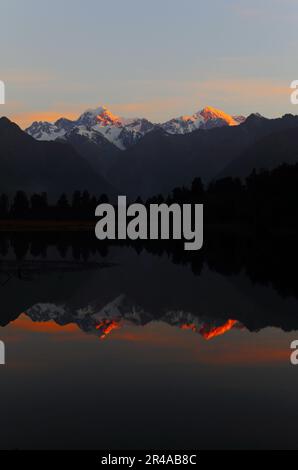 A majestic sunset at Lake Matheson with a reflection of Mount Cook and ...