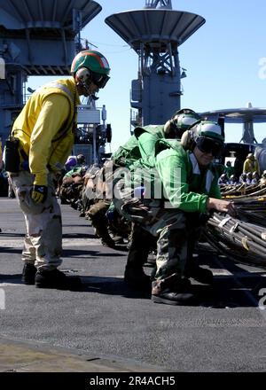 US Navy Air Department crew members practice rigging the emergency ...