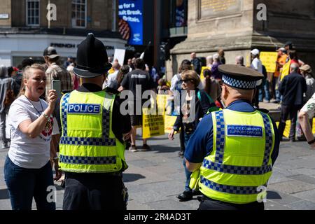 Three uniformed police officers in short sleeves wearing caps with ...