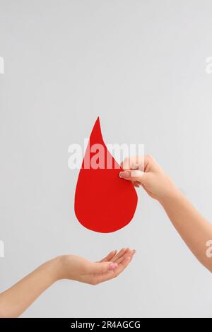 Women with paper blood drop on lilac background, closeup. World Donor ...