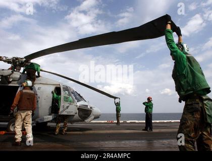 US Navy Sailors prepare to fold the tail rotor of an SH-60B Seahawk ...