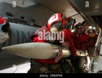 US Navy Aviation Ordnancemen load a 500lb. Mk-82 general purpose bomb ...