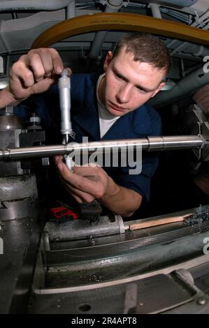 US Navy Machinery Repairman Fireman uses a caliper to measure a bearing ...