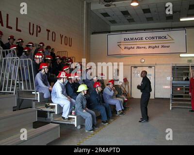 US Navy Damage Controlman 2nd Class shows children shipboard fire ...
