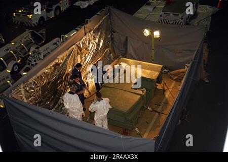 US Navy Sailors work throughout the night performing routine ...