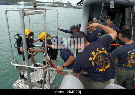 US Navy Royal Thai Navy diver Ensign has a MK-21 diving helmet fastened ...
