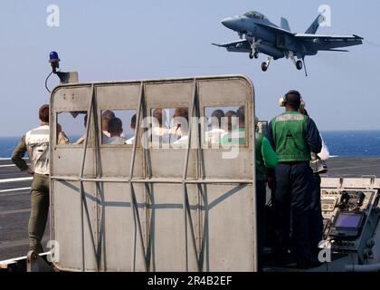 Landing signal officers (LSO) watch an F/A-18C Hornet aircraft of ...