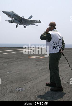 A landing signal officer (LSO) watches as an F-4S Phantom II aircraft ...