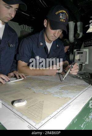 US Navy Quartermaster Seaman plots the ship's coordinates during watch ...