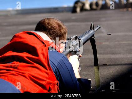 US Navy Torpedoman's Mate 2nd Class instructs a Sailor on the proper ...