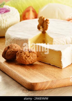 Different sorts of cheese on a wooden board Stock Photo - Alamy