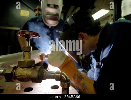 US Navy Hull Technician Fireman practices welding techniques aboard the ...