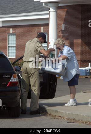 US Navy A U.S. Navy Sailor helps a Hurricane Katrina victim fill out ...